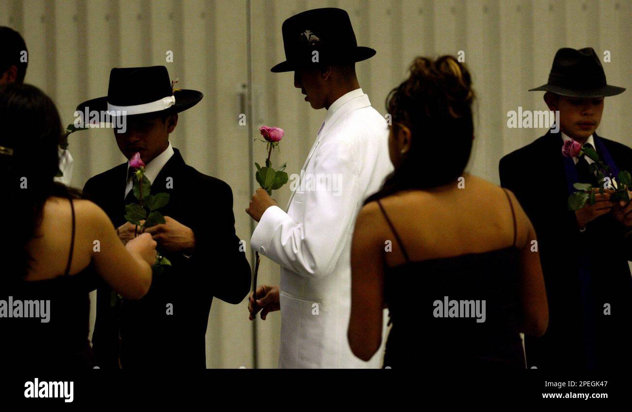 Pedro Rincon, center, holds a rose that represents a year in the life ...