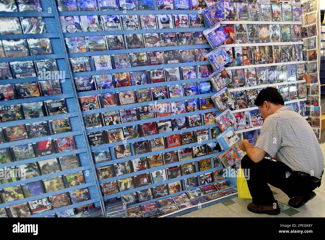 A Malaysian looks at a software disc for sale at a shopping mall where ...