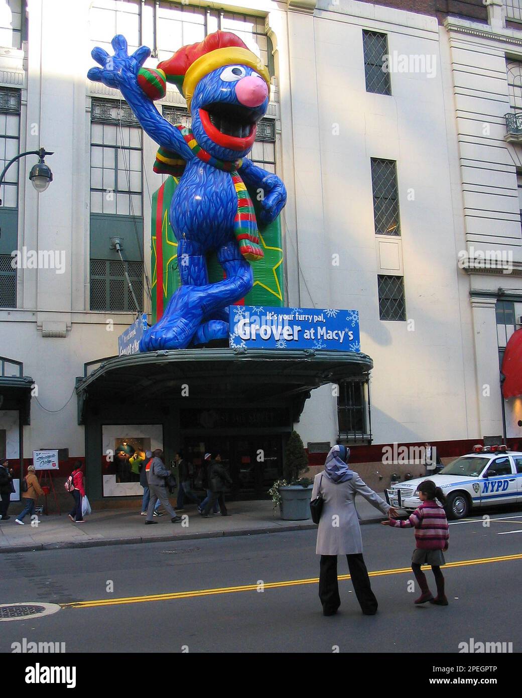 A mother and her child pause on Seventh Avenue in New York City to view ...