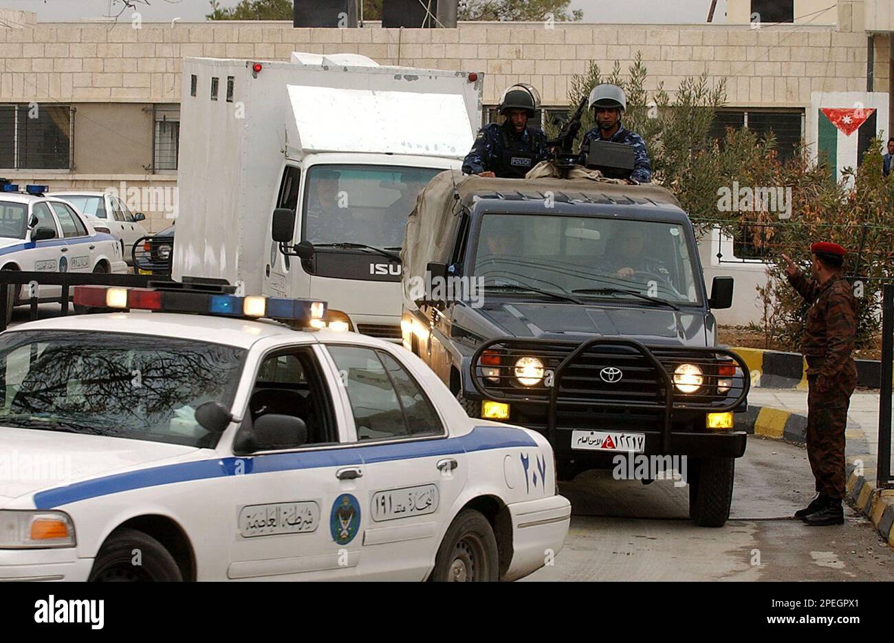 Jordanian policemen guard a prison vehicle with nine terror suspects ...