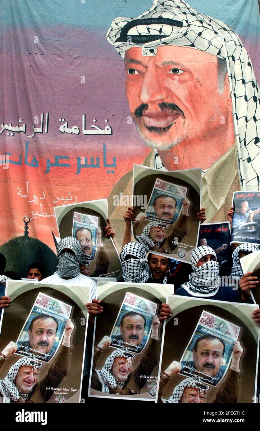 Under a big poster of late Palestinian leader Yasser Arafat, masked ...