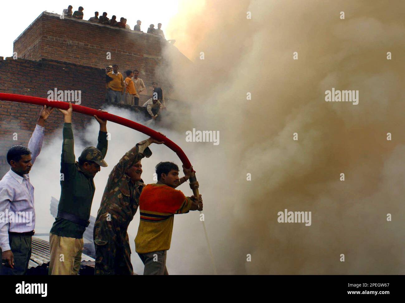 Locals help Indian paramilitary soldiers to douse a major fire at a ...