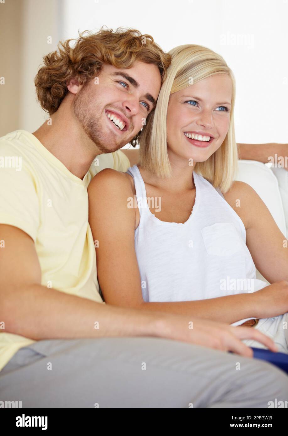 So comfortable with each other. A happy young couple sitting on their ...