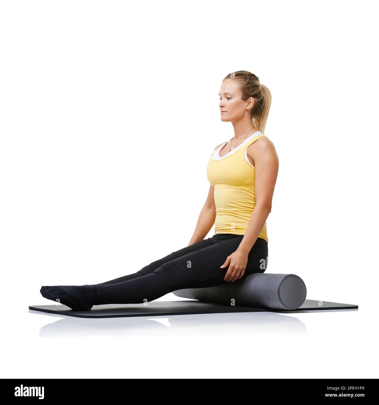 Working out takes focus and dedication. A young woman sitting on a foam ...