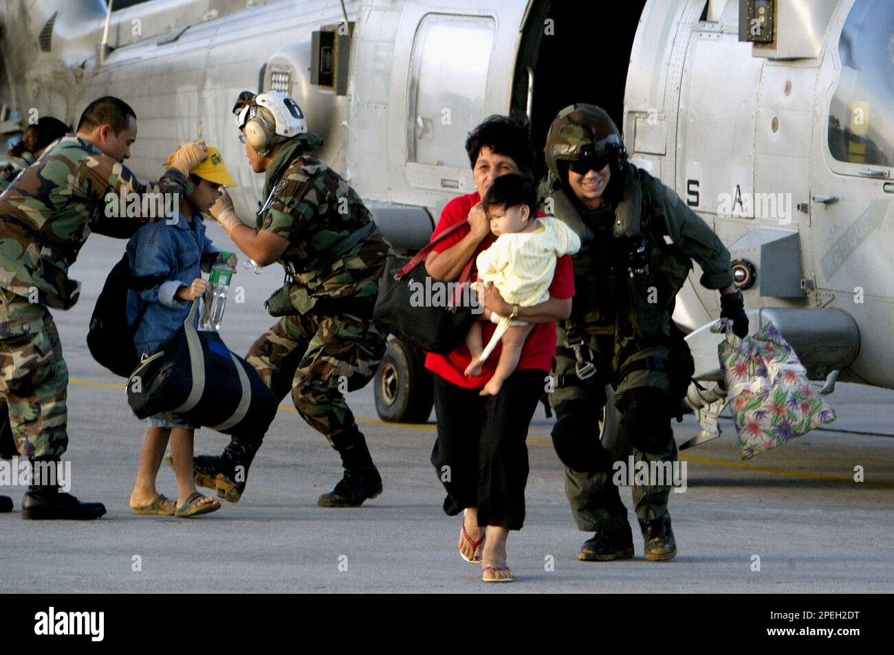 American soldiers help typhoon victims off a US Navy HH-60 Seahawk ...