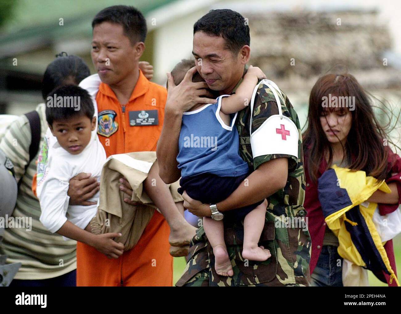 An army doctor and a rescue worker carry sick Filipino children towards ...