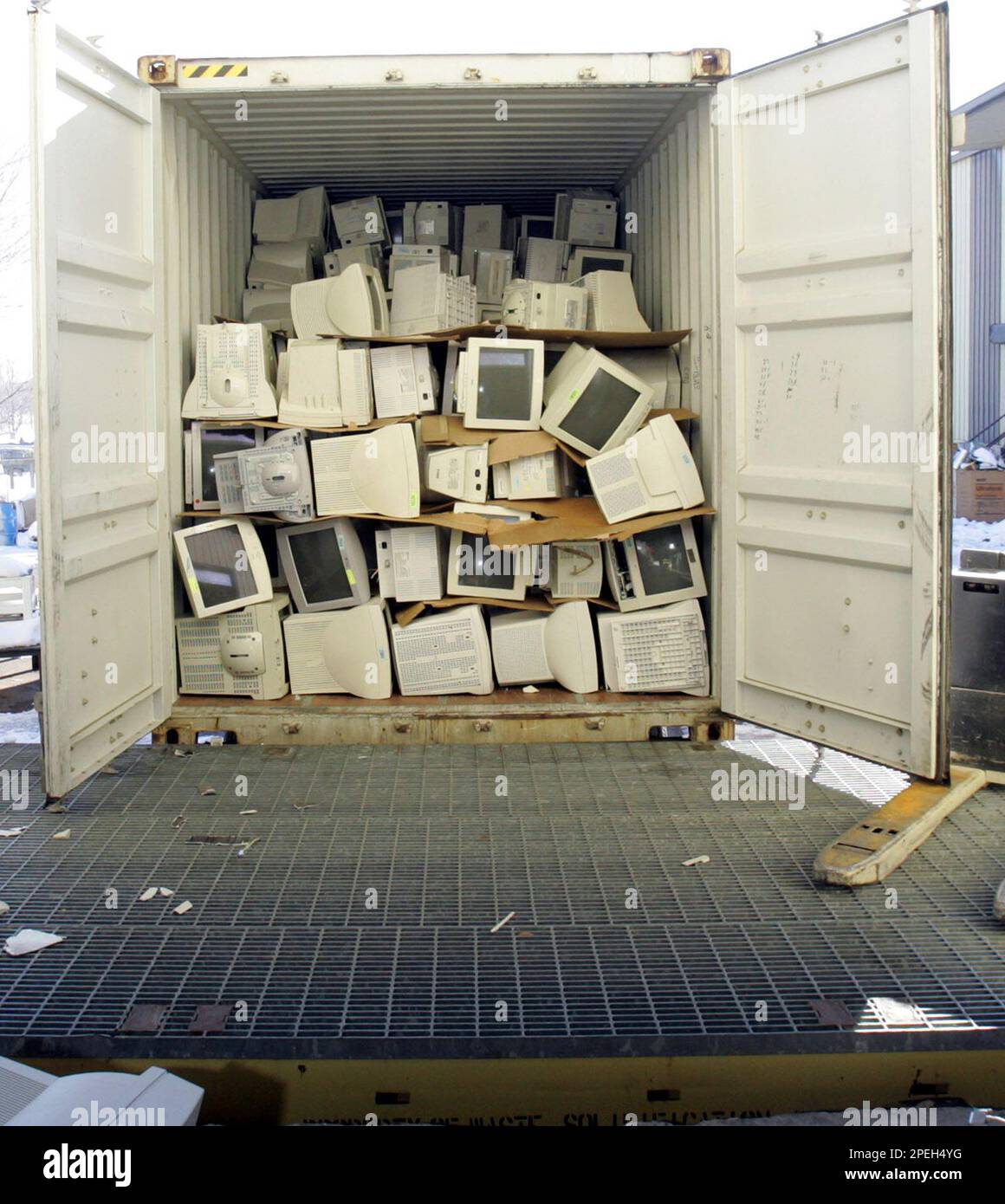 An almost full shipping container containing computer monitors sits on ...