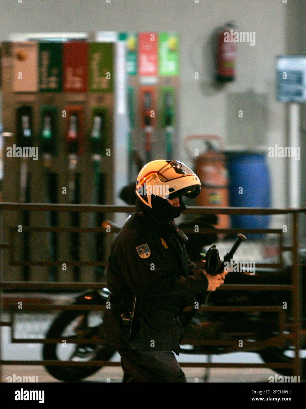 A police officer patrols the gas-pump area in a gas station on the ...