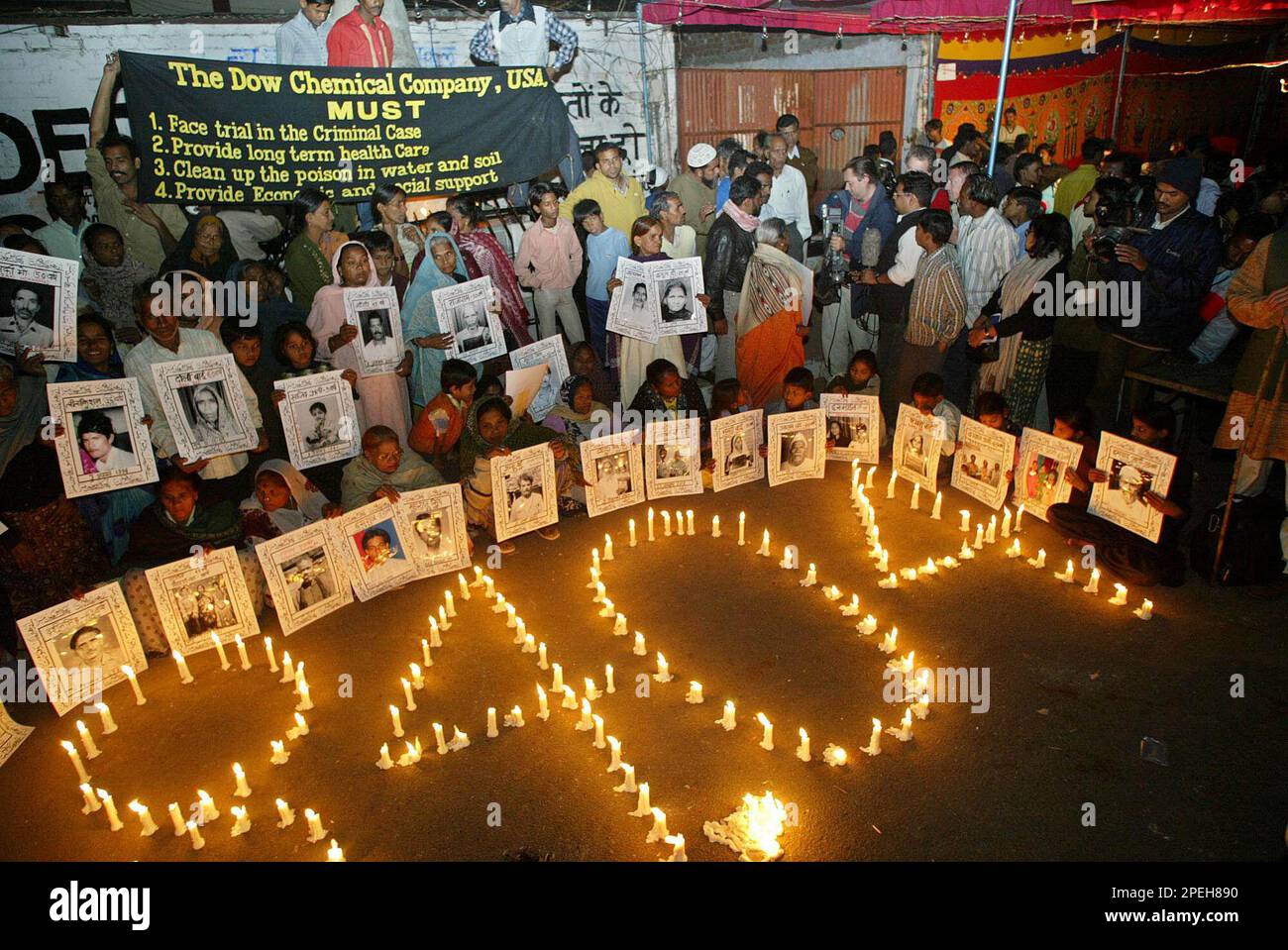 Survivors of the Bhopal Gas Tragedy hold photographs of relatives who ...