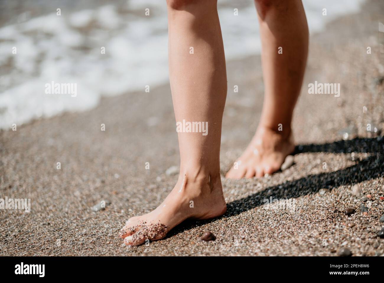 A woman walks along the beach, legs close-up. Barefoot woman sta Stock ...