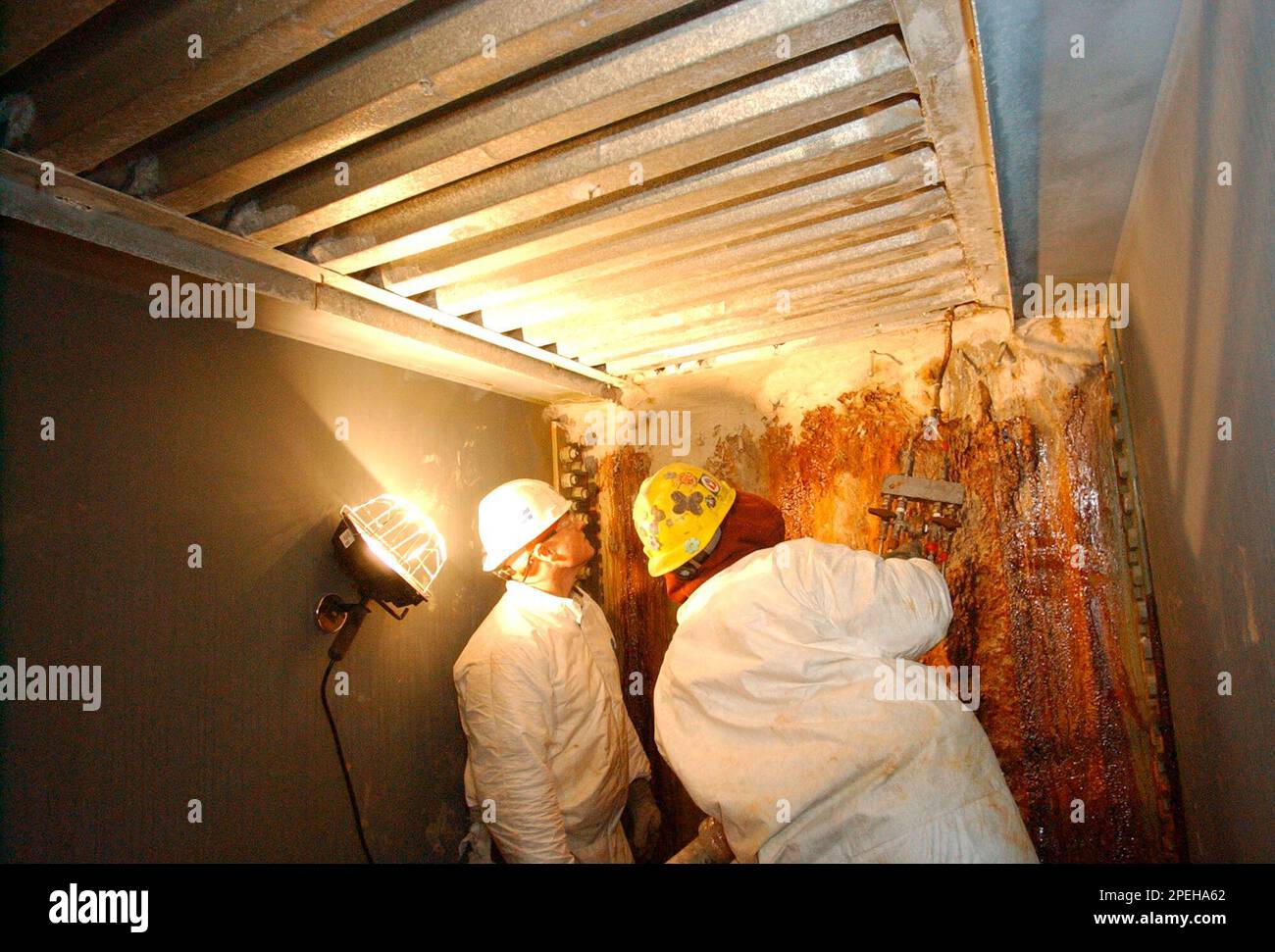 Laborers Pat Joyce, center, and Jody Mellor, right, use an injection ...