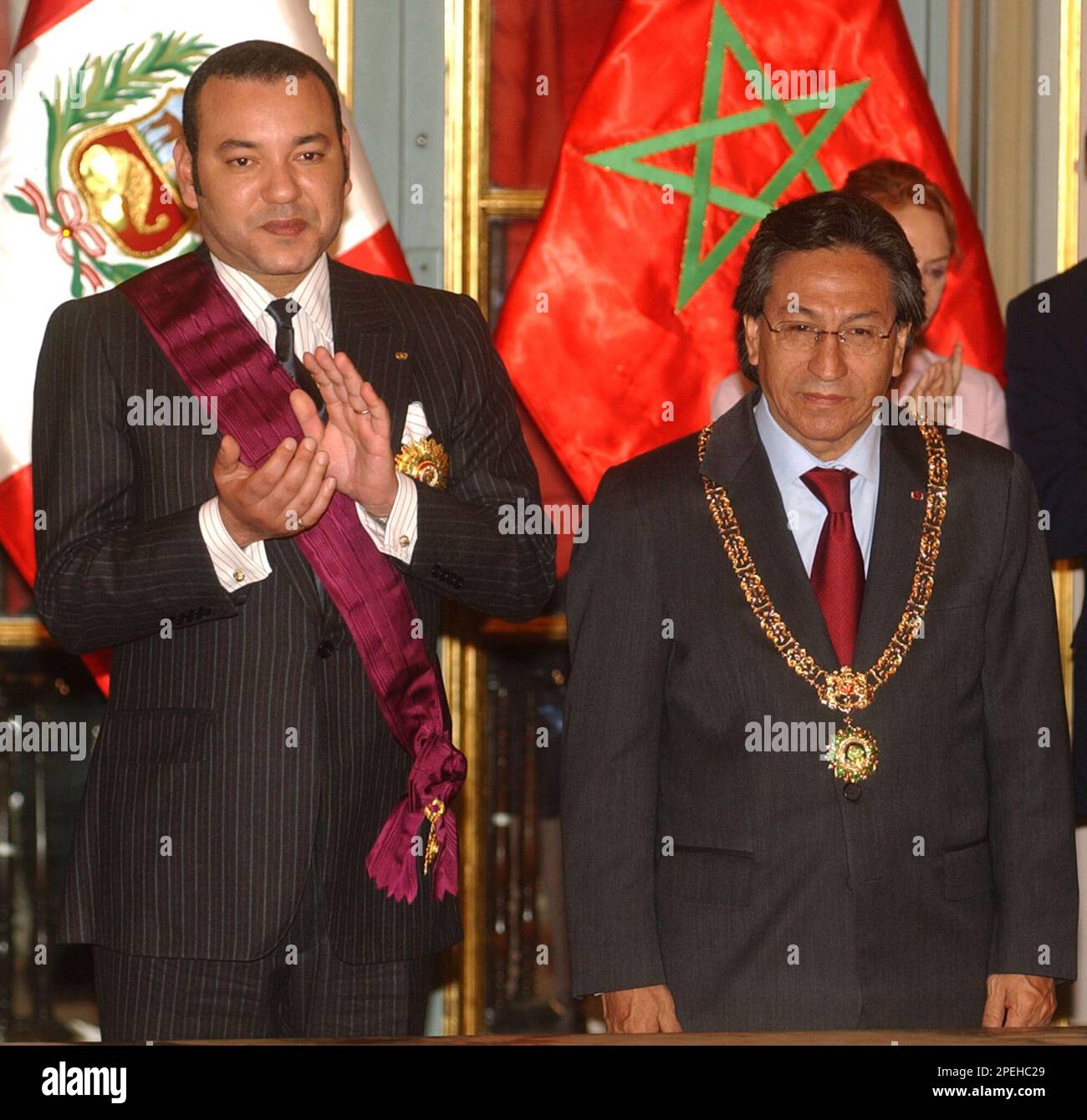 Morocco's King Mohammed VI, left, applauds Peru's President Alejandro Toledo, right, after he ...