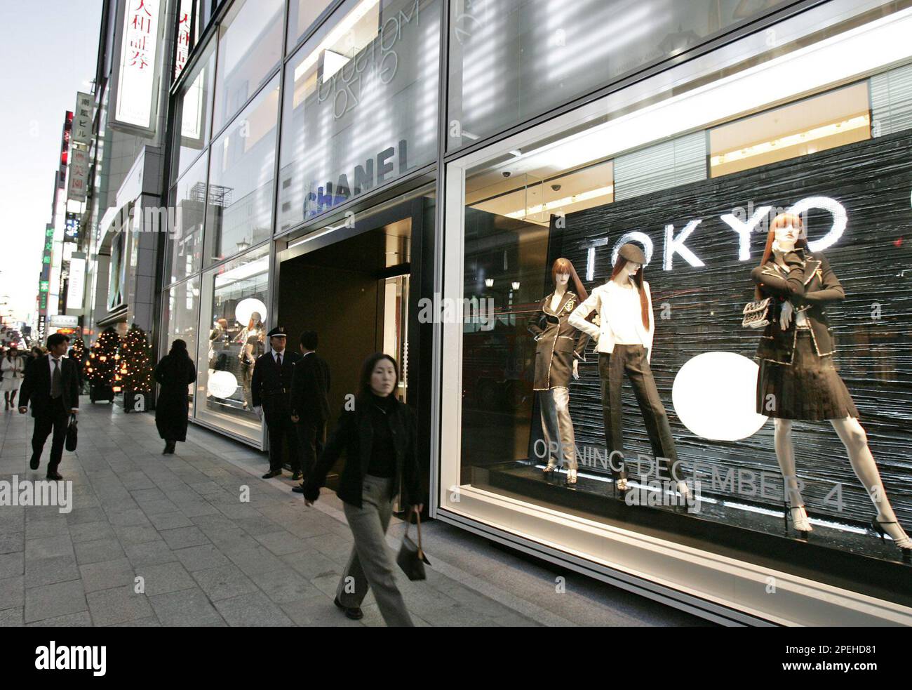 Pedestrians walk by a new Chanel store along the famed glitzy Ginza ...