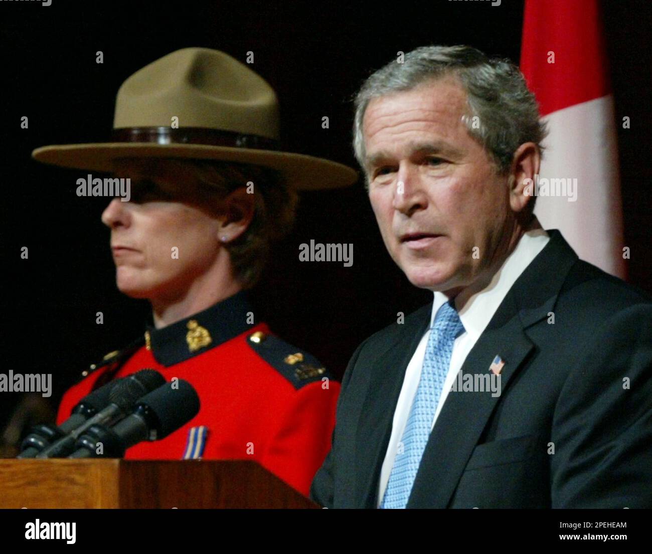 President Bush is flanked by a Royal Mounted Canadian Police officer as ...