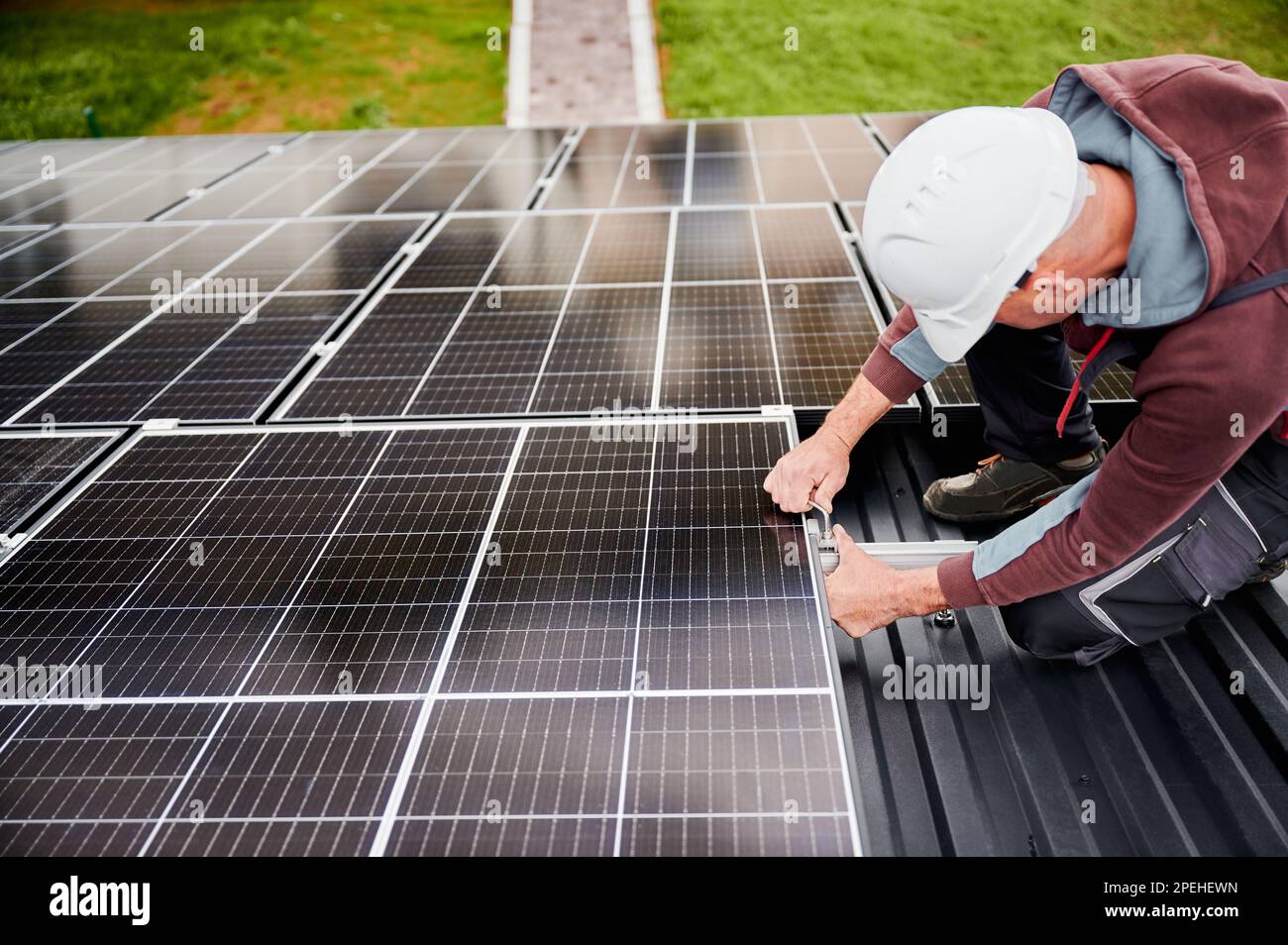 Man engineer mounting photovoltaic solar panels on roof of house ...