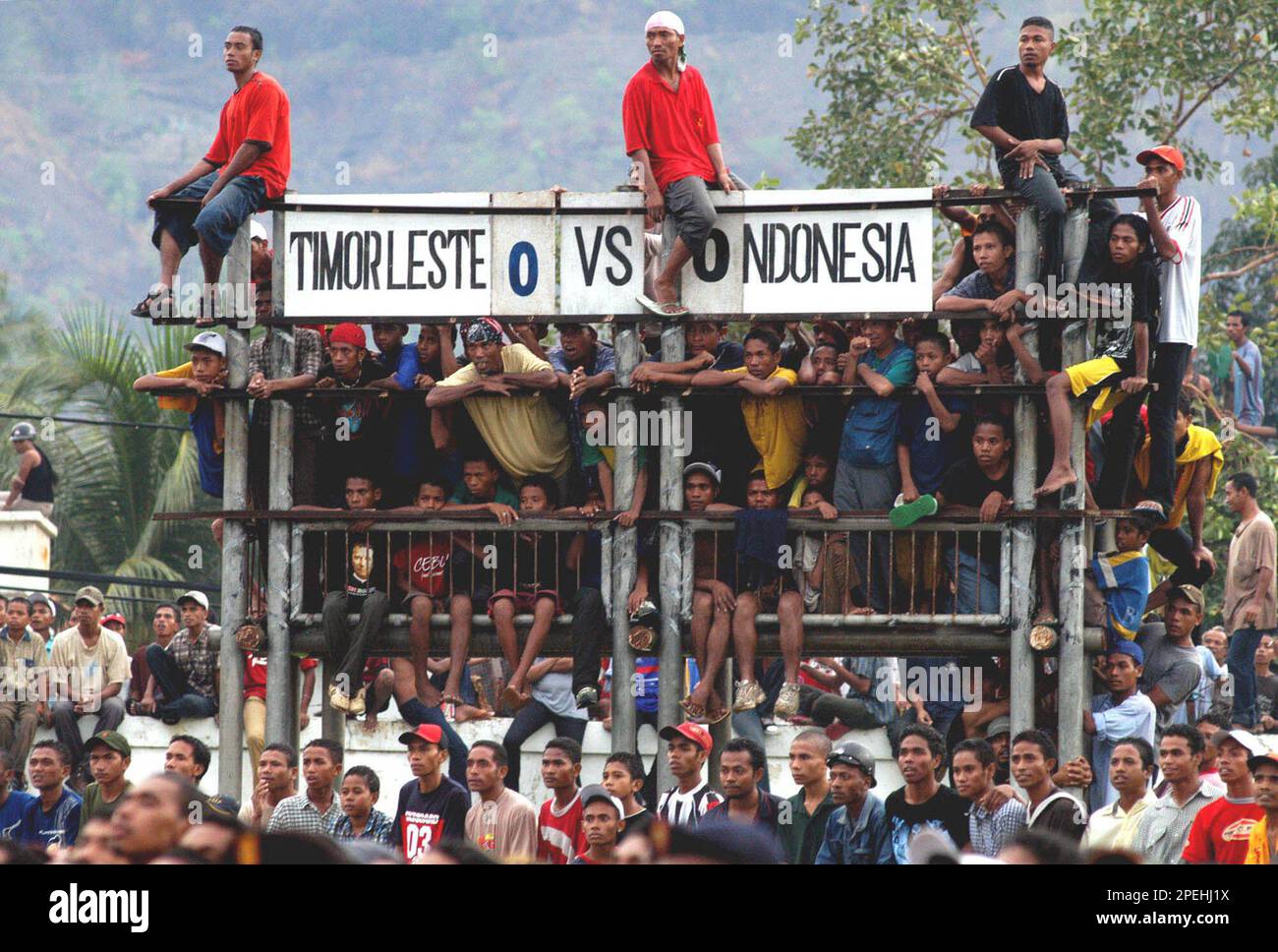 East Timorese crowd watch a wet soccer game between East Timor and ...