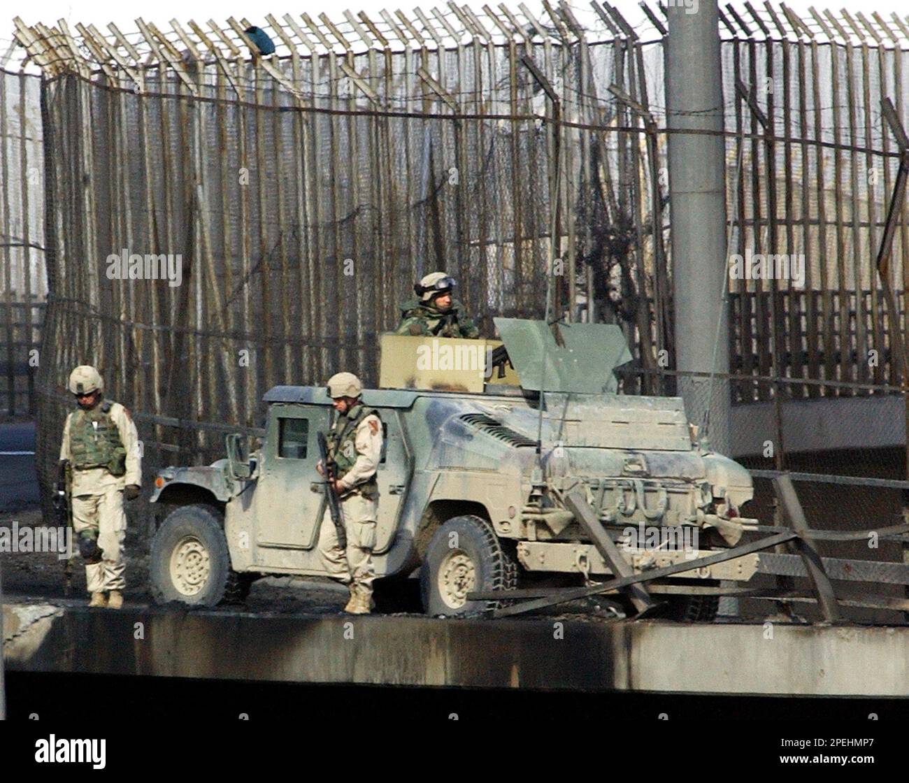 US soldiers secure the area after a road side bomb damaged an military ...