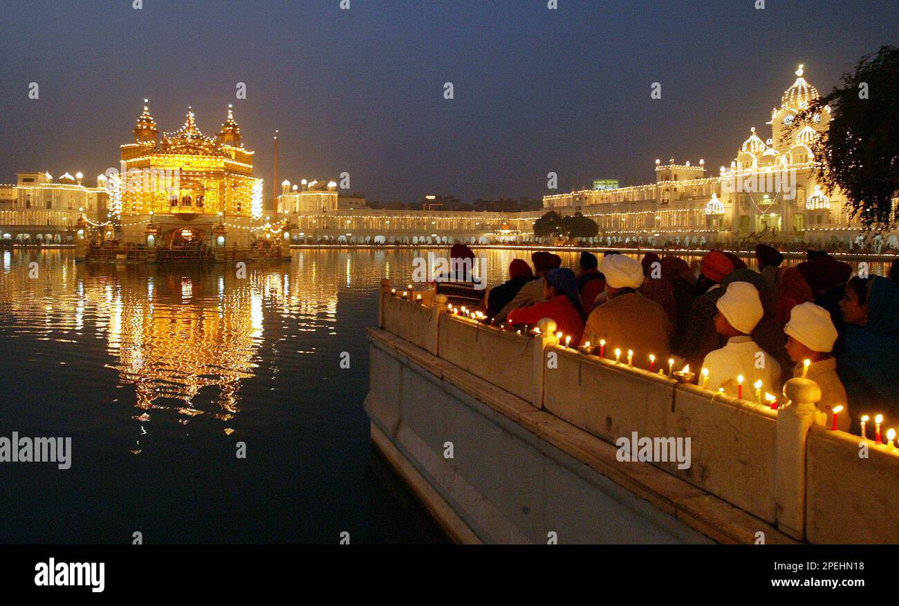 Sikh devotees pray before the illuminated Golden Temple, Sikhs holiest ...