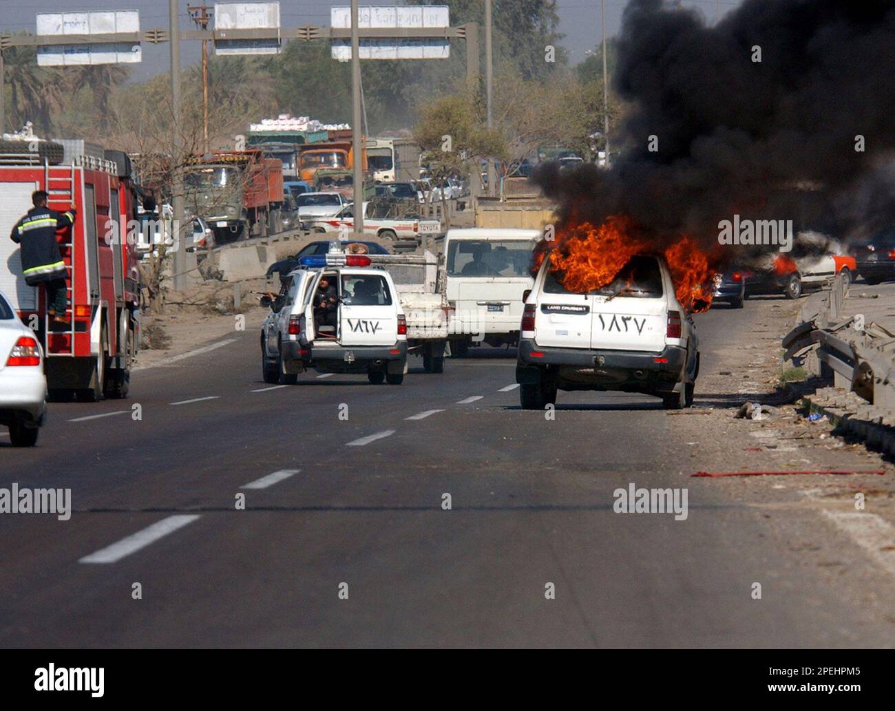 An Iraqi police car burns after it came under attack from unknown ...