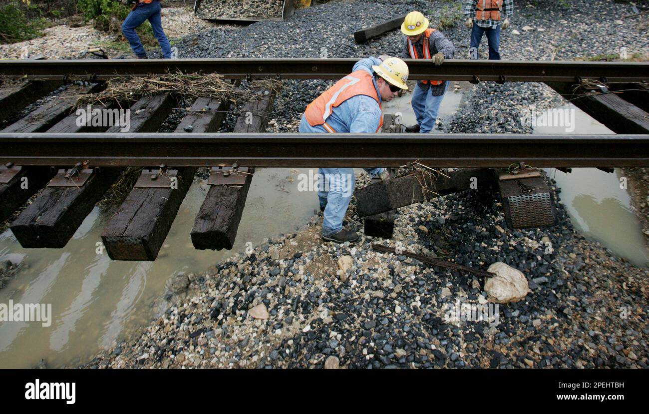 Union Pacific workers examine a railroad track that was washed out ...