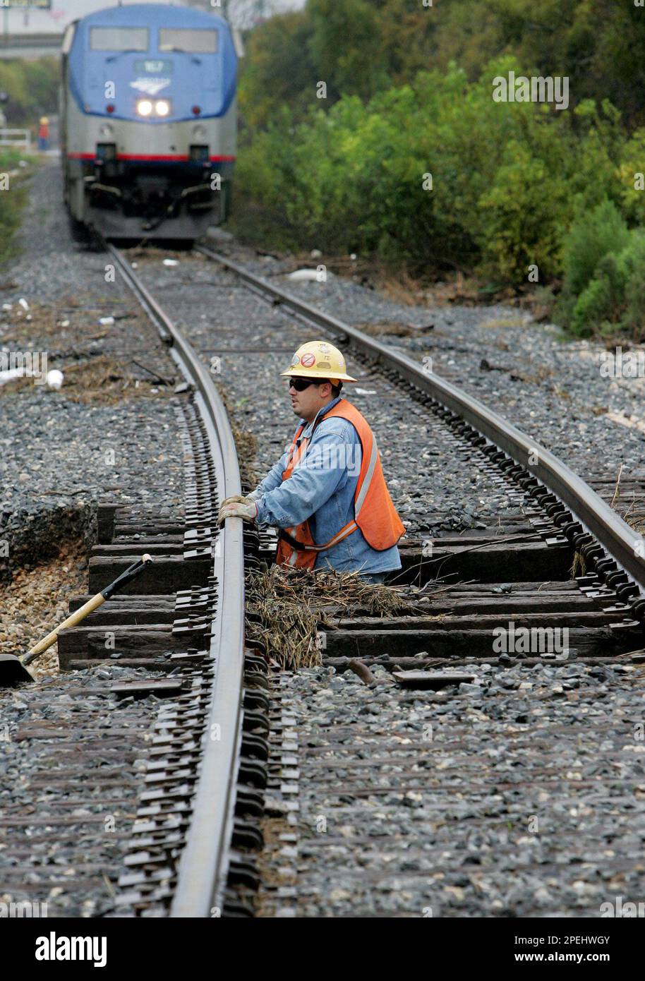 A Union Pacific worker examinies a railroad track that was washed out ...