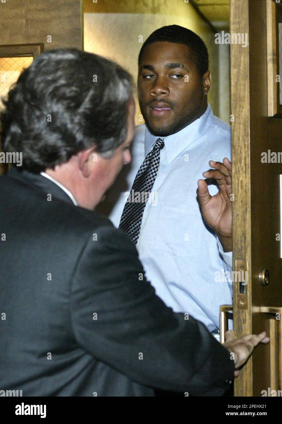 Nebraska football player Darren DeLone, right, is led from a Cleveland ...