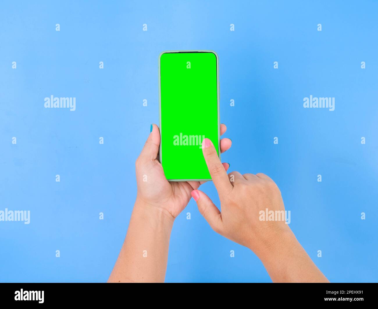 Female hand holding smartphone with mockup green screen on blue ... Female hand holding smartphone with mockup green screen on blue ...