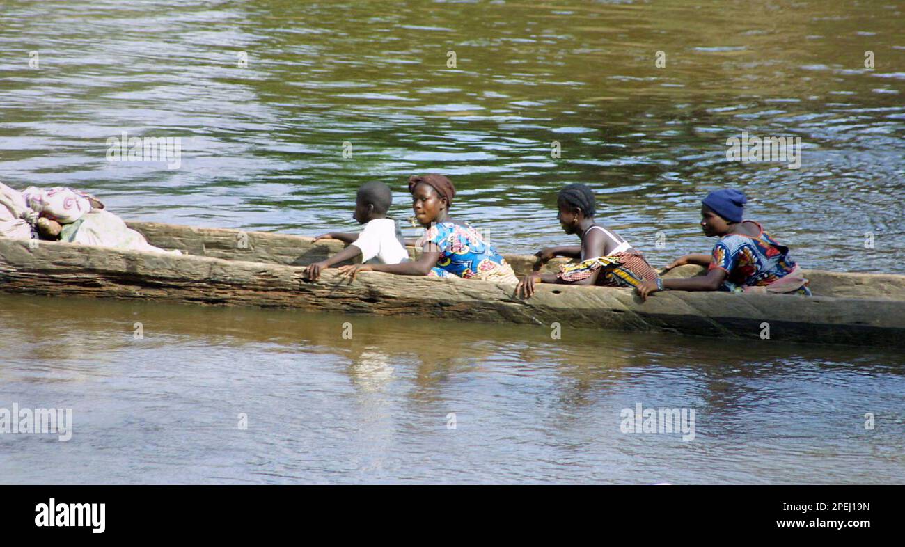 Ivorian refugees cross the Cestos river into the Liberian border town ...