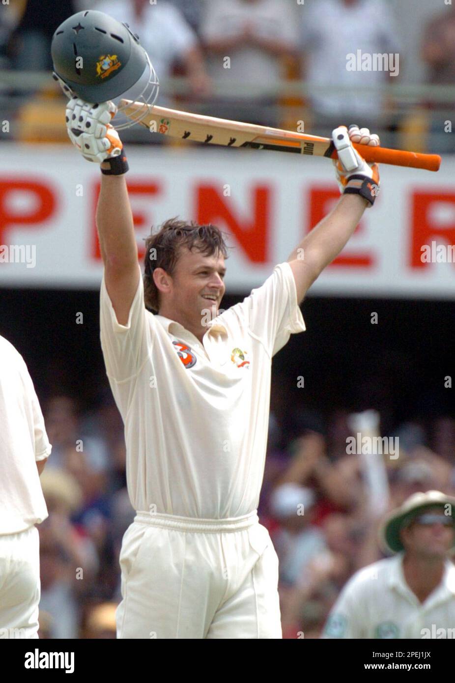 Australian batsman Adam Gilchrist raises his bat after scoring 100 runs ...