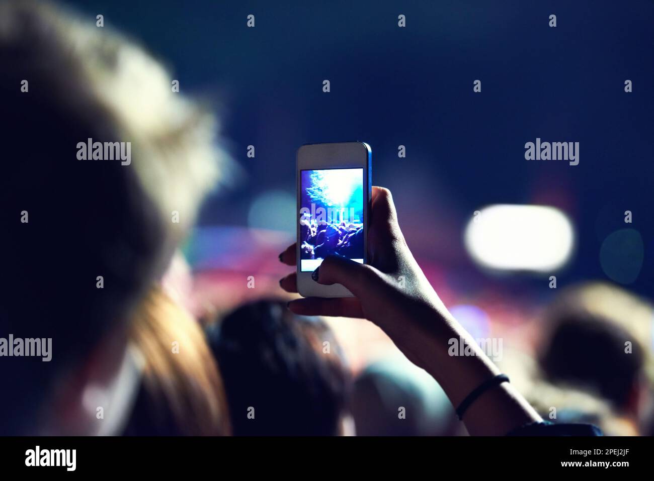 Capturing the awesomeness. An audience member taking a photograph of ...