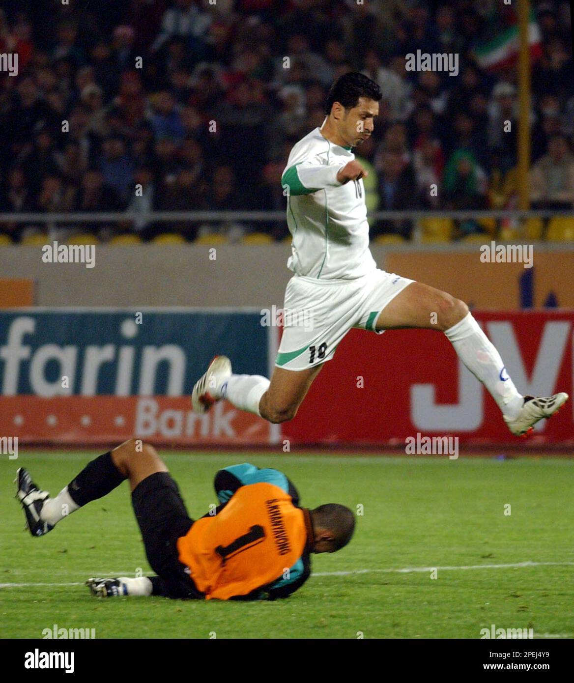 Iran's Ali Daei, right, jumps over Laos's goalkeeper Khanyavaono during ...