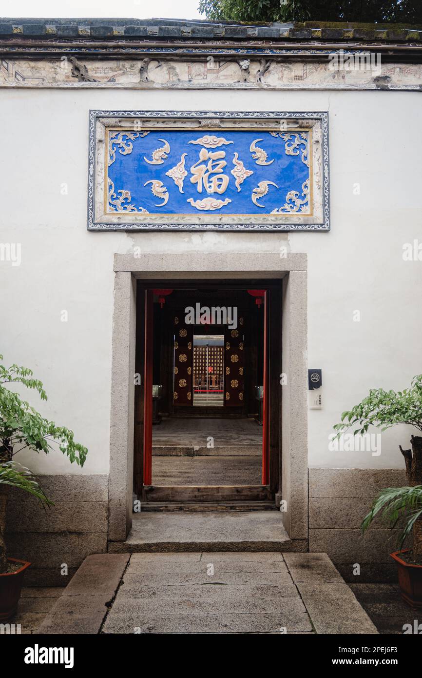 The entrance of an old Chinese house with a blue sign on the wall Stock ...