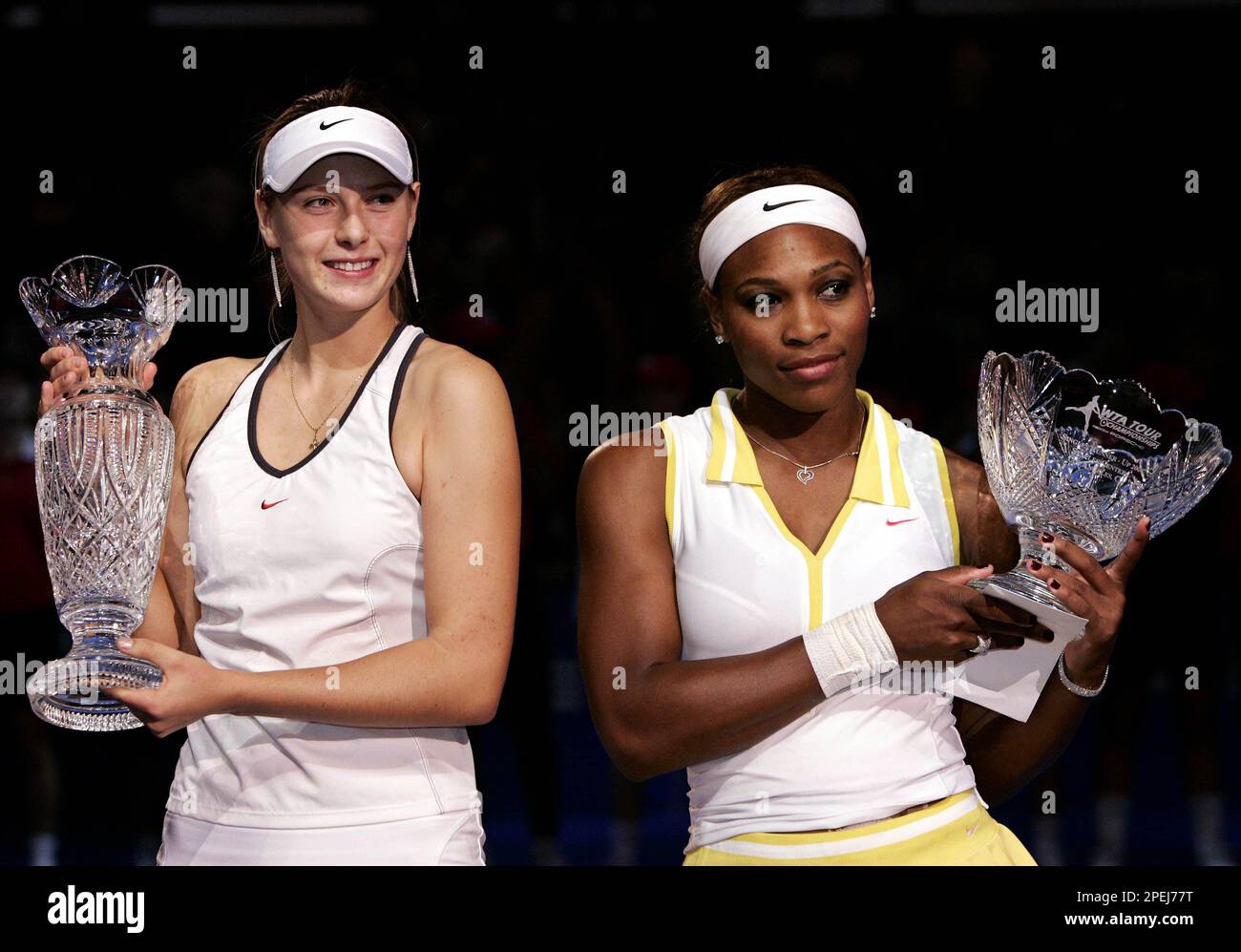 Russia's Maria Sharapova, left, and Serena Williams hold their trophies ...