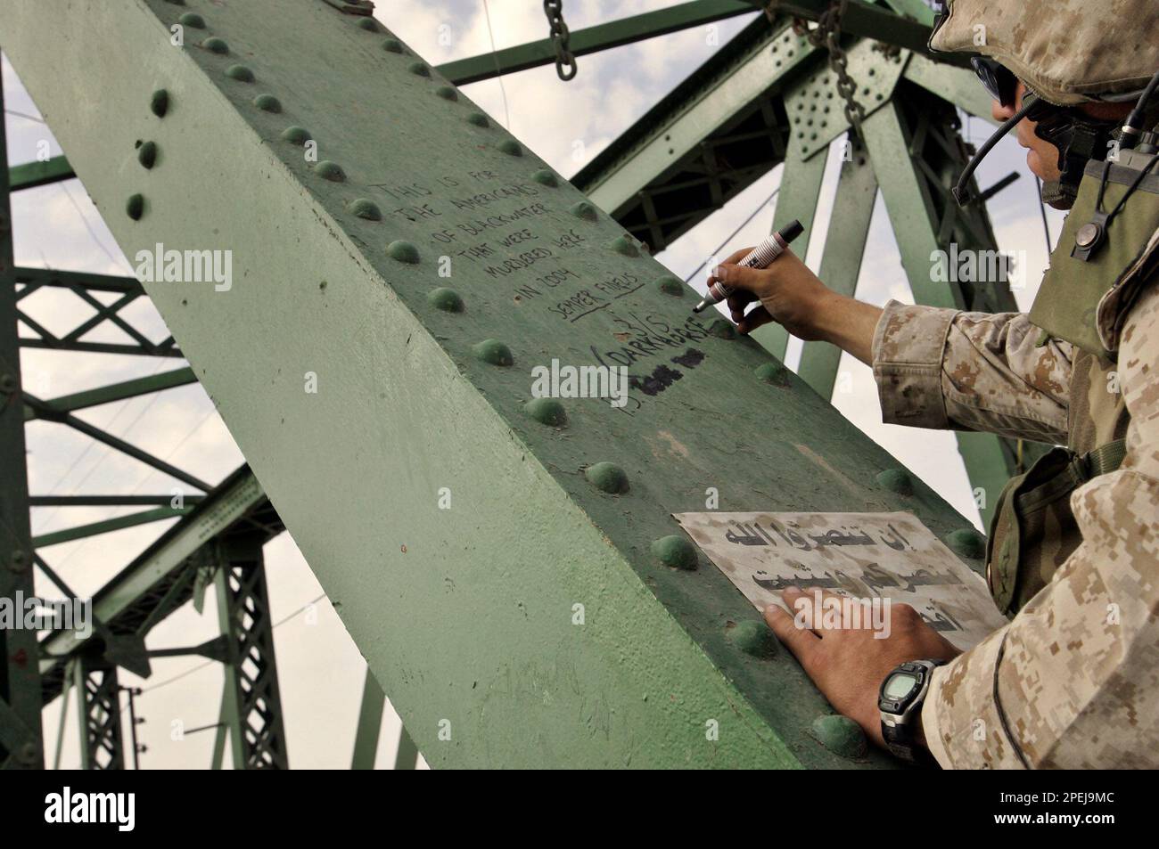 A US Marine of the 1st Division writes the words "Dark Horse" on a beam ...