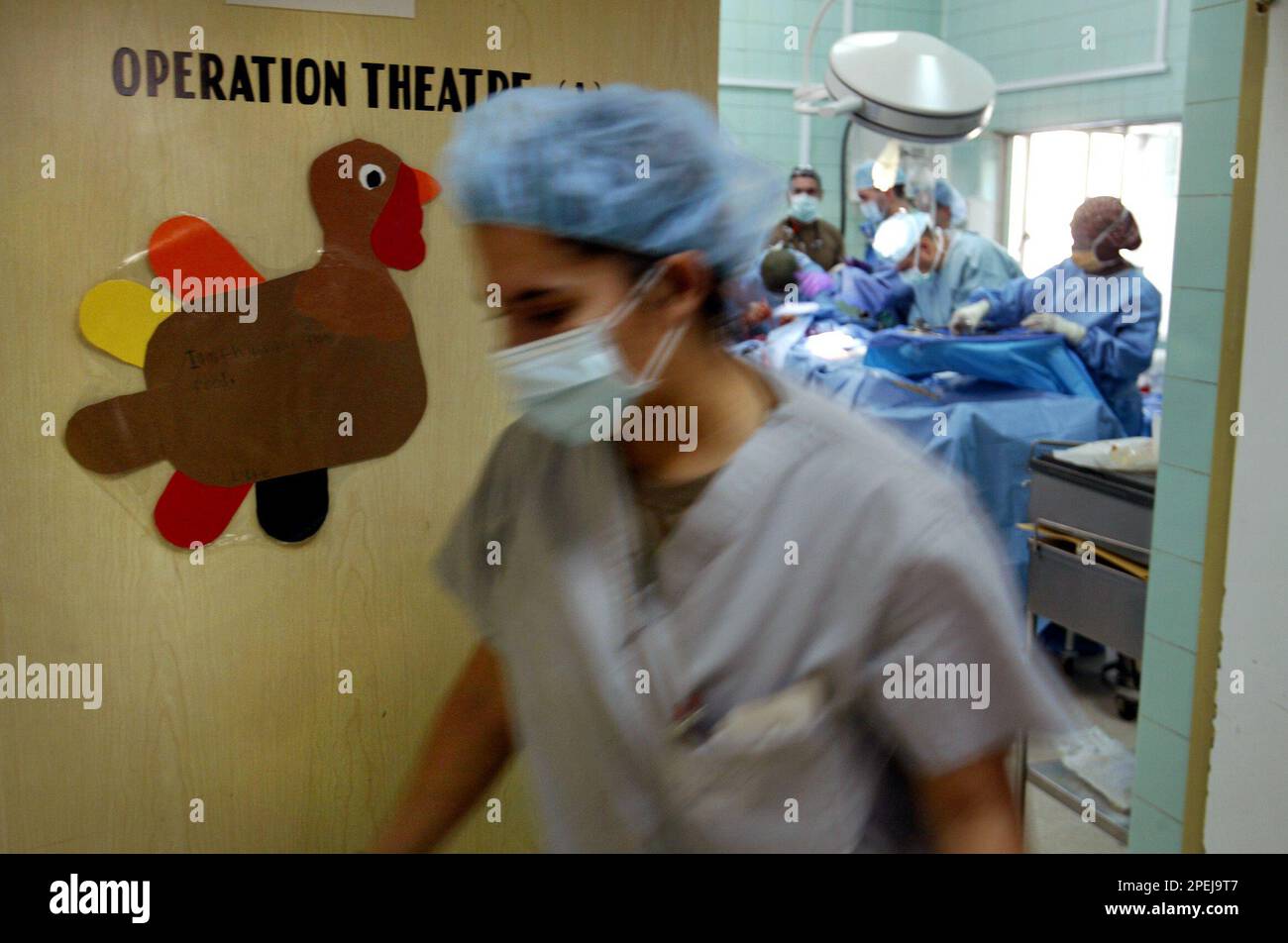 A U.S. Army nurse leaves an operating room as surgeons work to save the ...