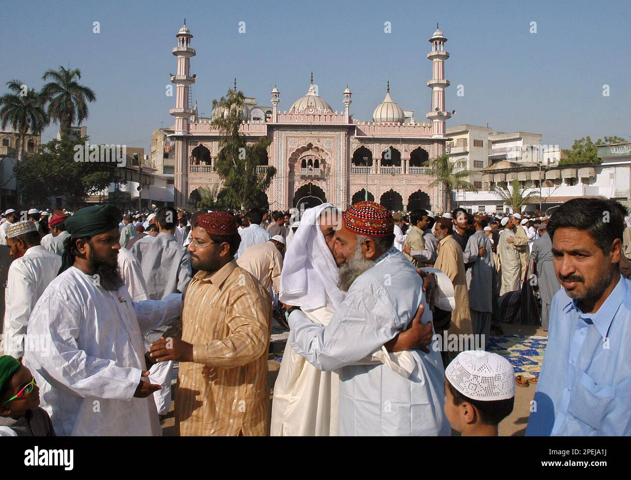 Pakistani Muslims share Eid greeting after Eid Al-Fitr prayer at a ...