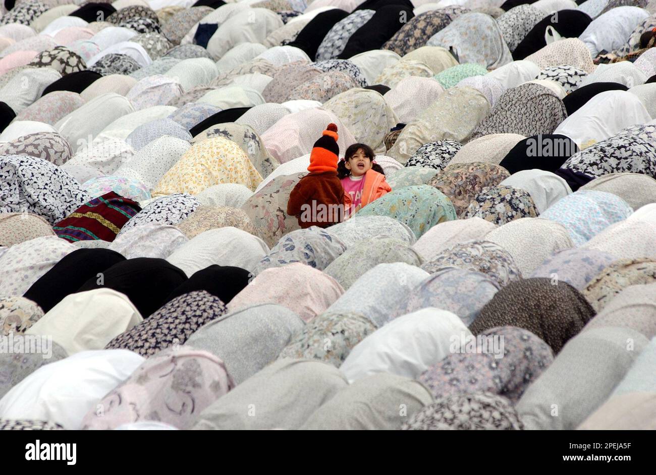 Two children sit as Iranian Muslim women offer morning Eid prayers in ...