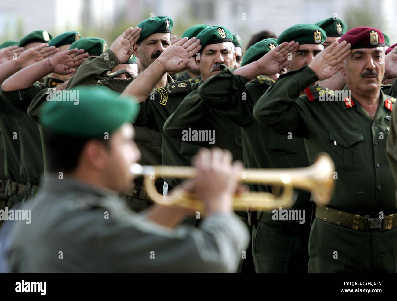 Palestinian police officers salute during a service at the grave of ...