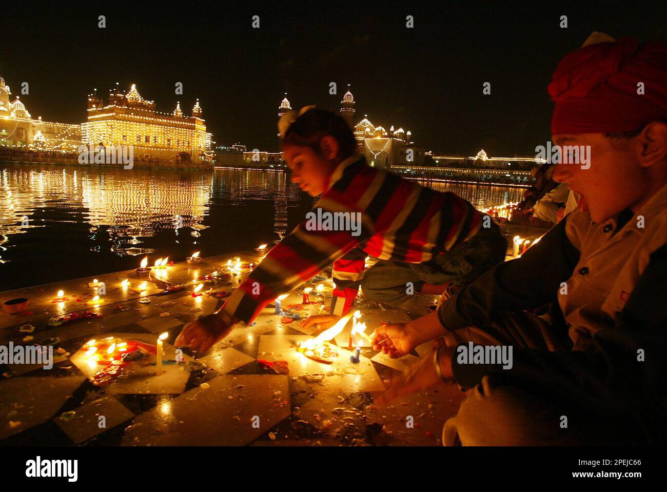 Sikh devotees light candles while participating in the Diwali ...