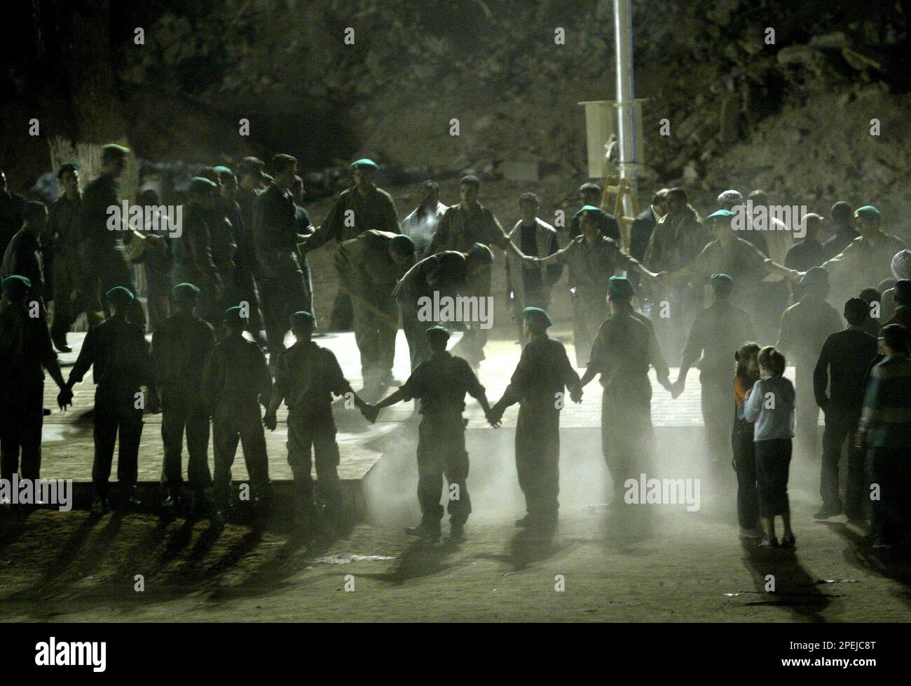 Palestinian security officers and mourners gather around the grave of ...