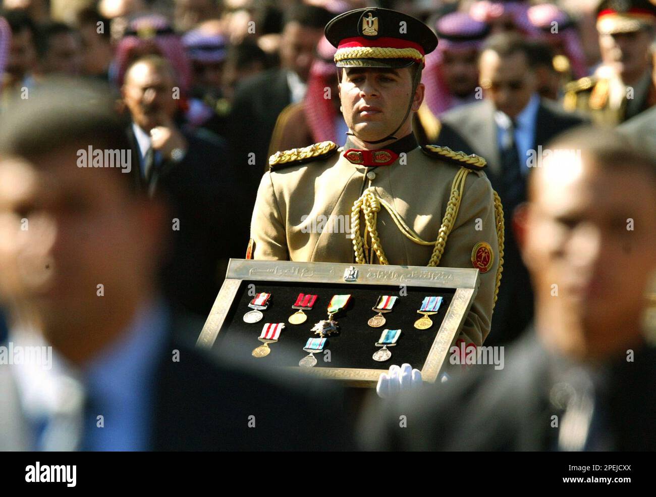 An Egyptian soldier carries Yasser Arafat's medals, as he walks behind ...