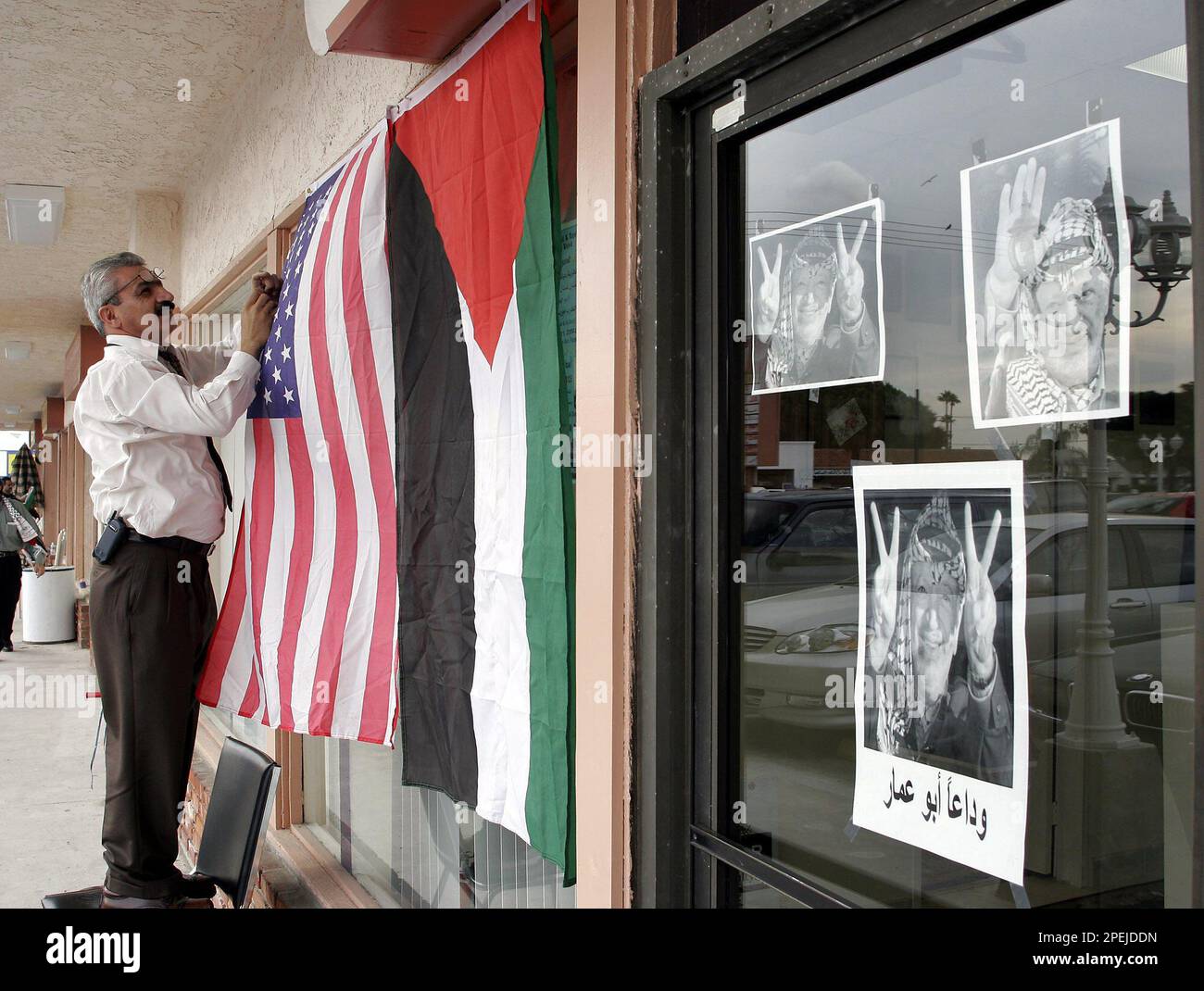 Ray Saeid, editor-in-chief of the Arab World newspaper, hangs an U.S ...