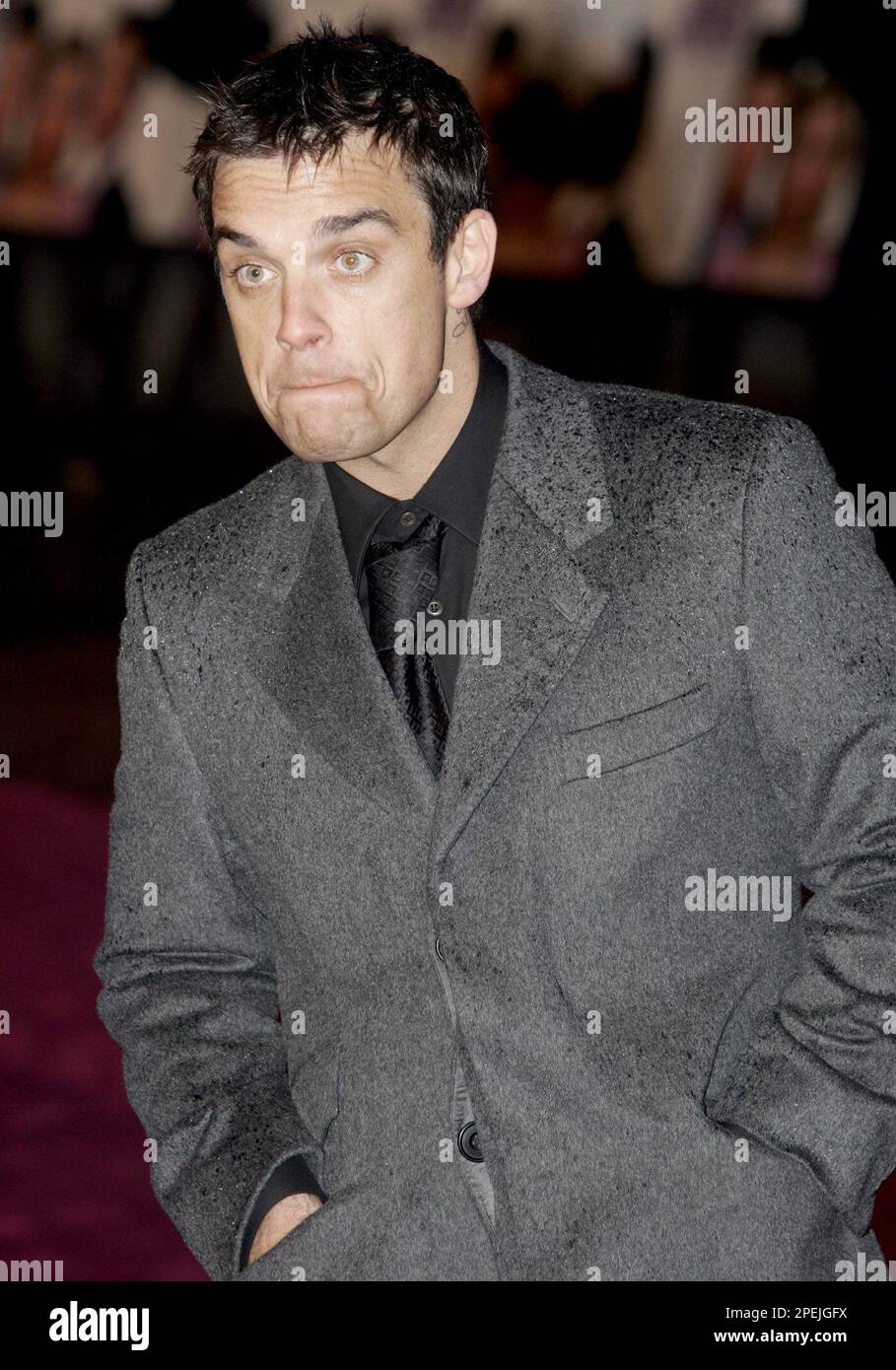 Pop star Robbie Williams makes a face as he arrives for the premiere of ...
