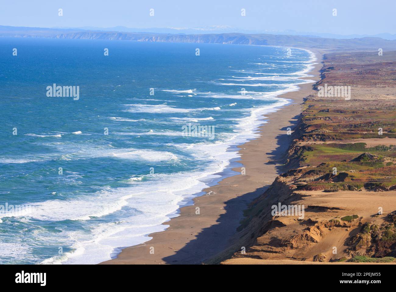 Steep sand dunes by long beach on coast of Marin County, California ...