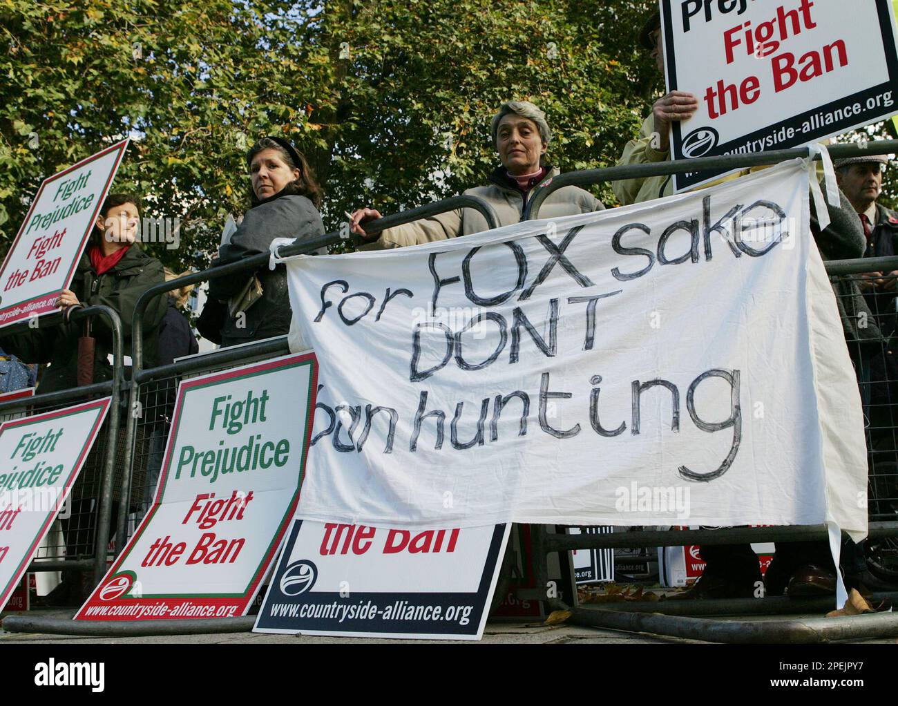 Pro-fox hunting protesters stand behind steel crash barriers and their ...
