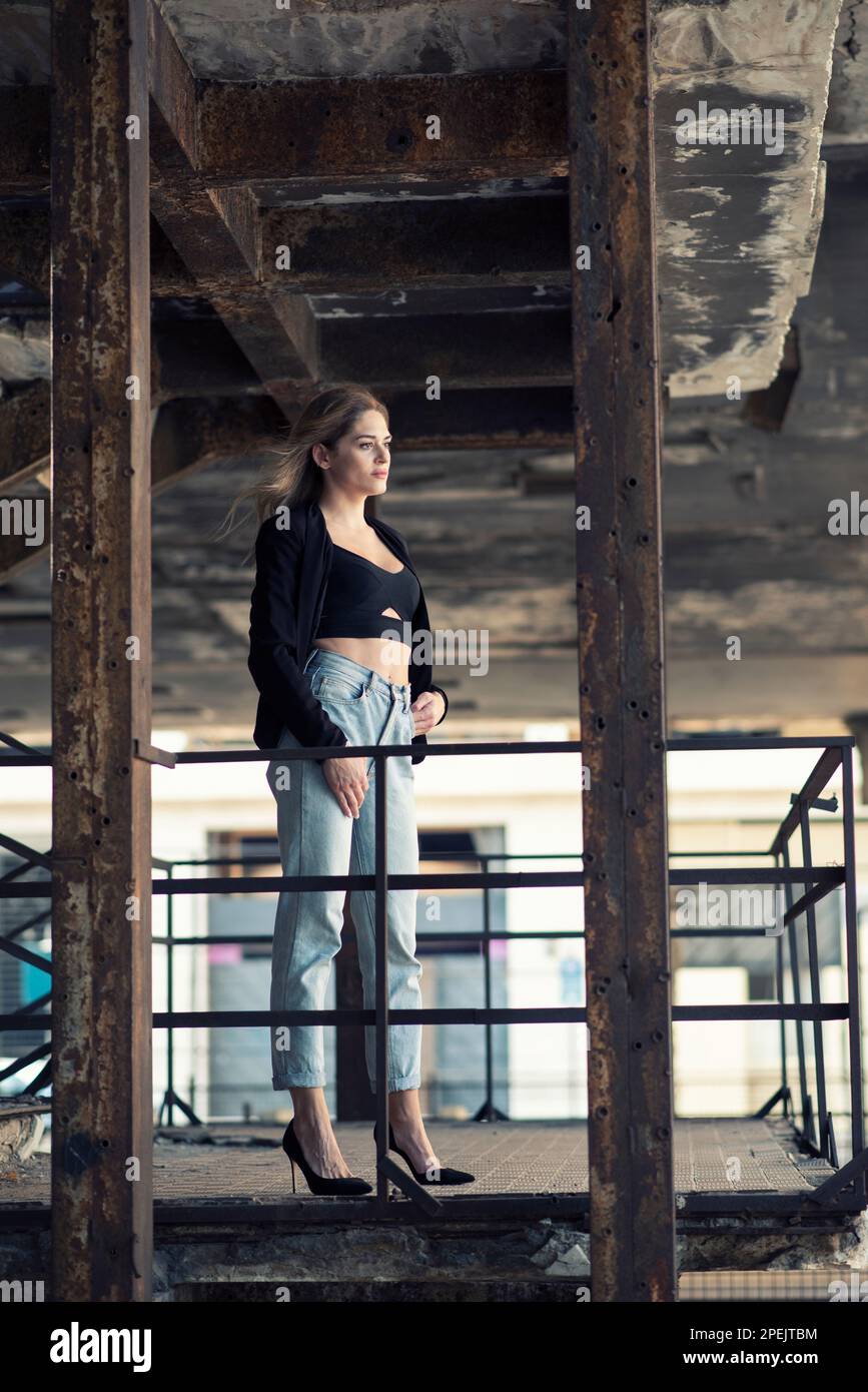 Beautiful serious woman standing inside a derelict building looking ...