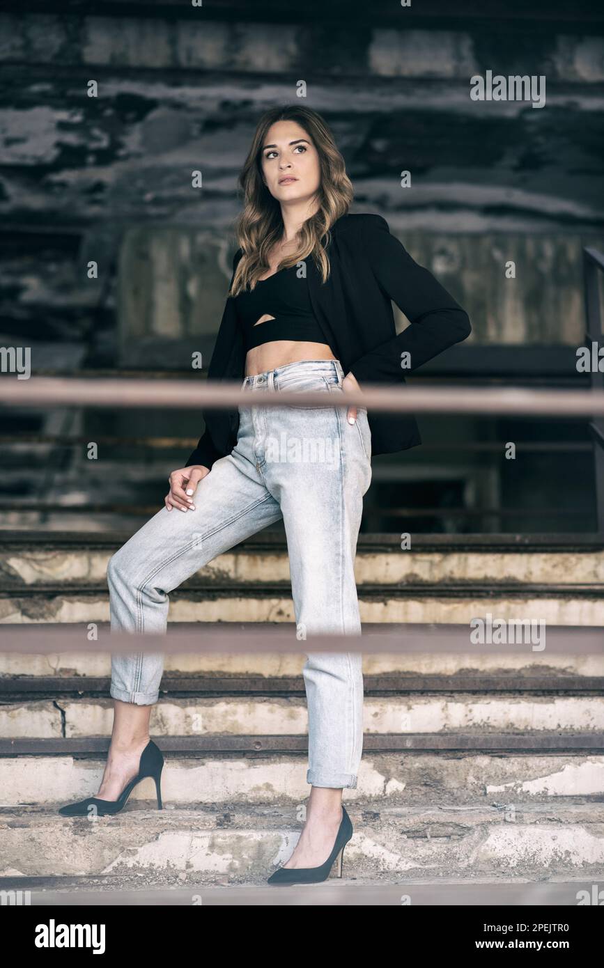 Beautiful serious woman standing inside a derelict building looking ...