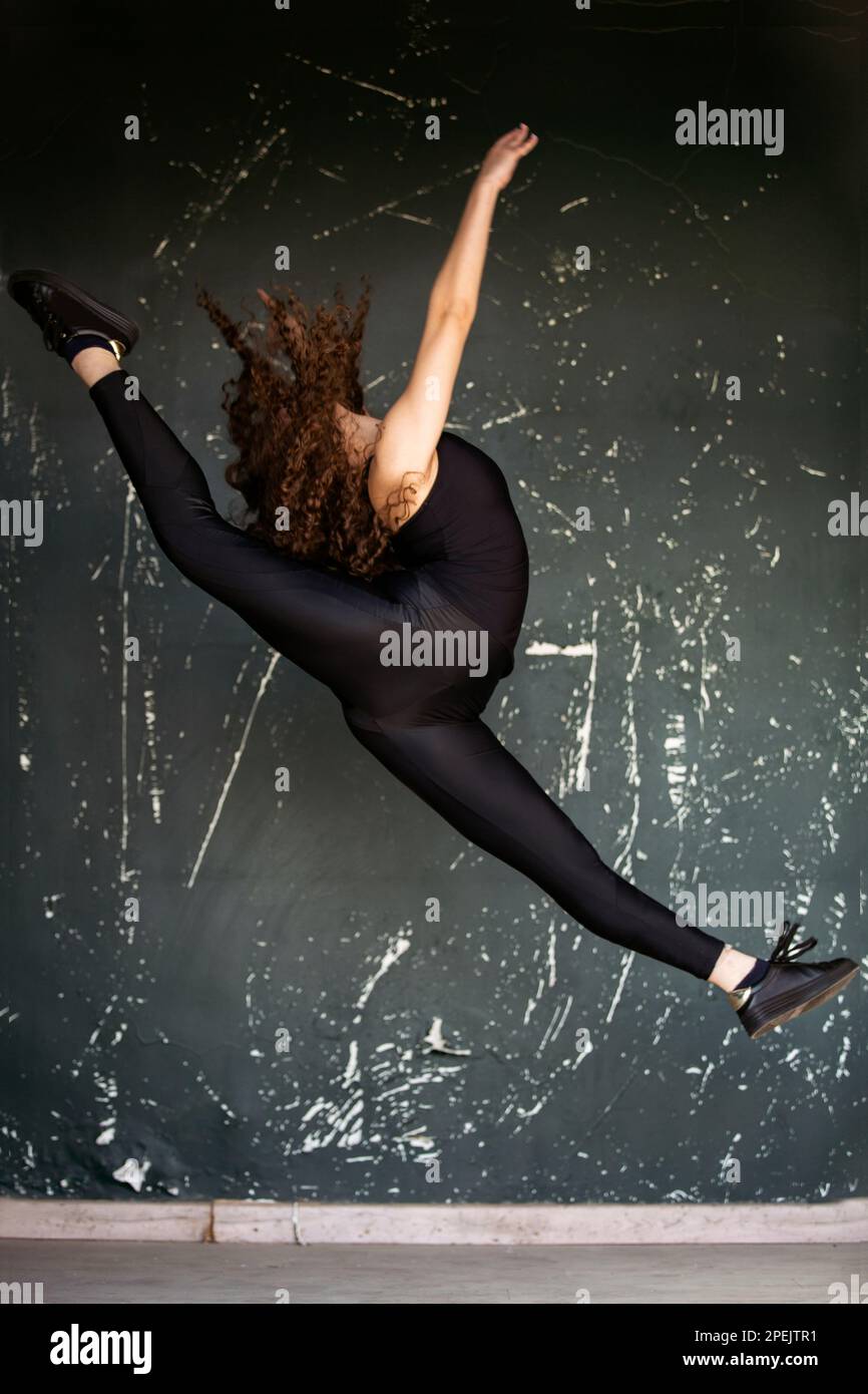 Flexible teenage girl doing the splits miod-air Stock Photo - Alamy