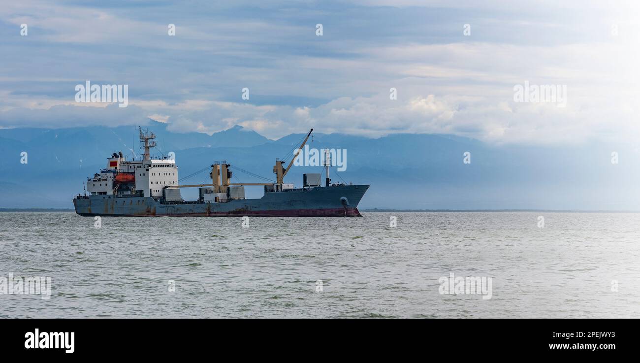 Large cargo container ship sailing against the volcano Stock Photo - Alamy