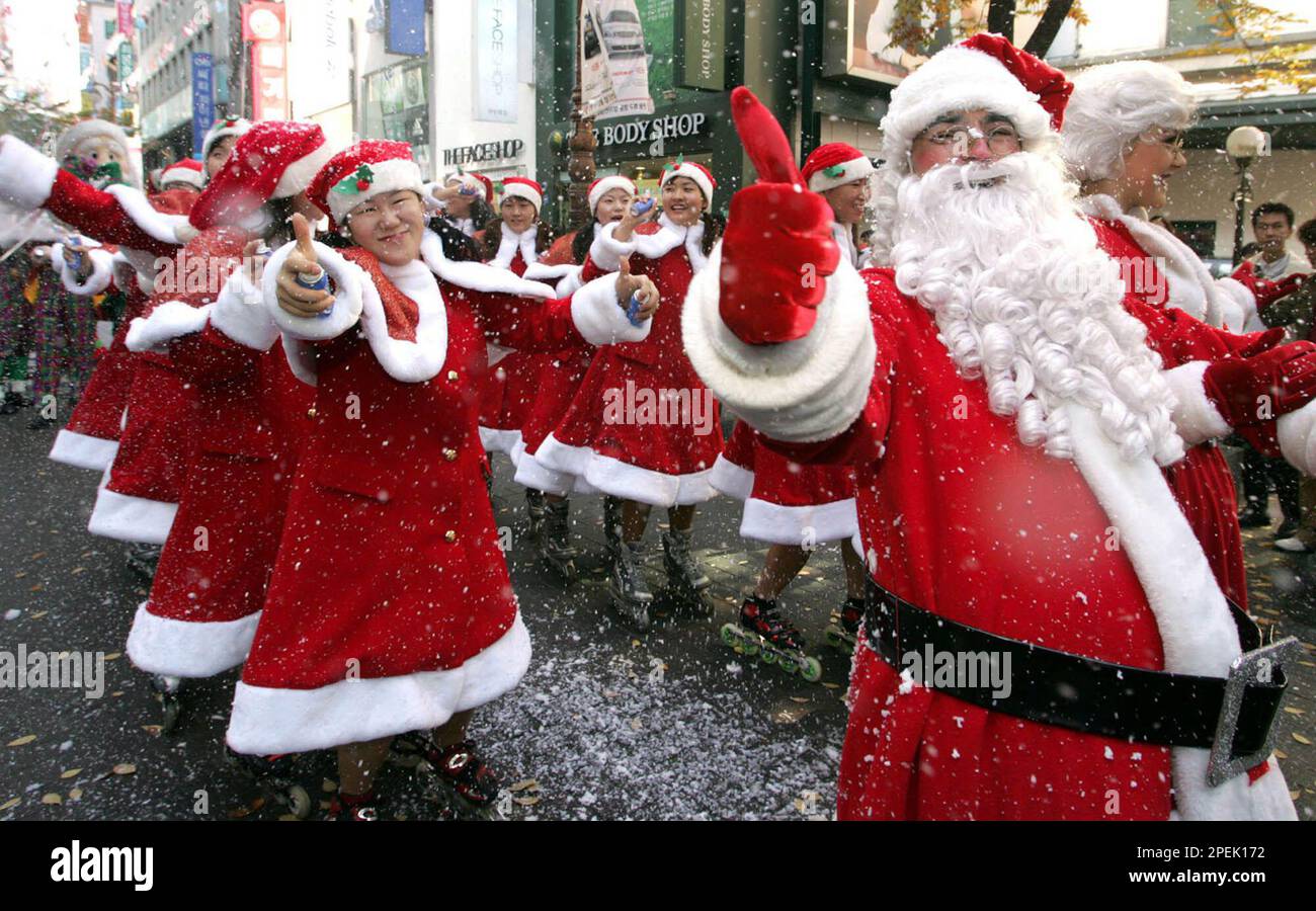 South Koreans in Santa Claus costume spray the artificial snow during a ...